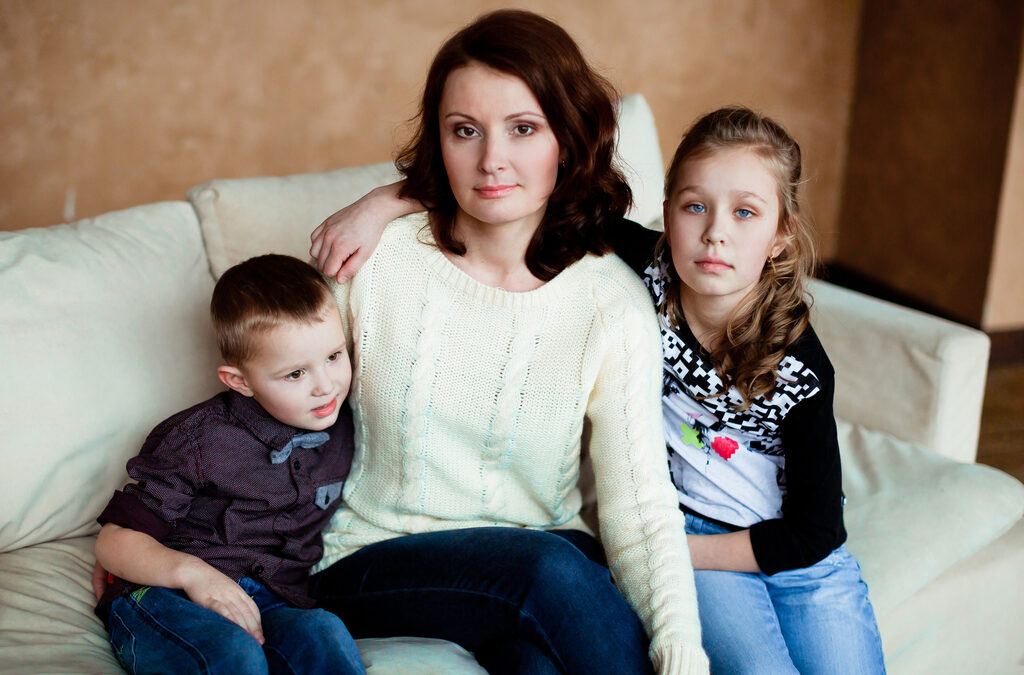 Mom with her two children sitting on the couch at home - South Bay ...